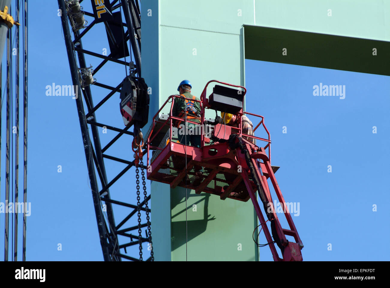 Two Worker installing a metal bridgehead in a harbor Stock Photo - Alamy