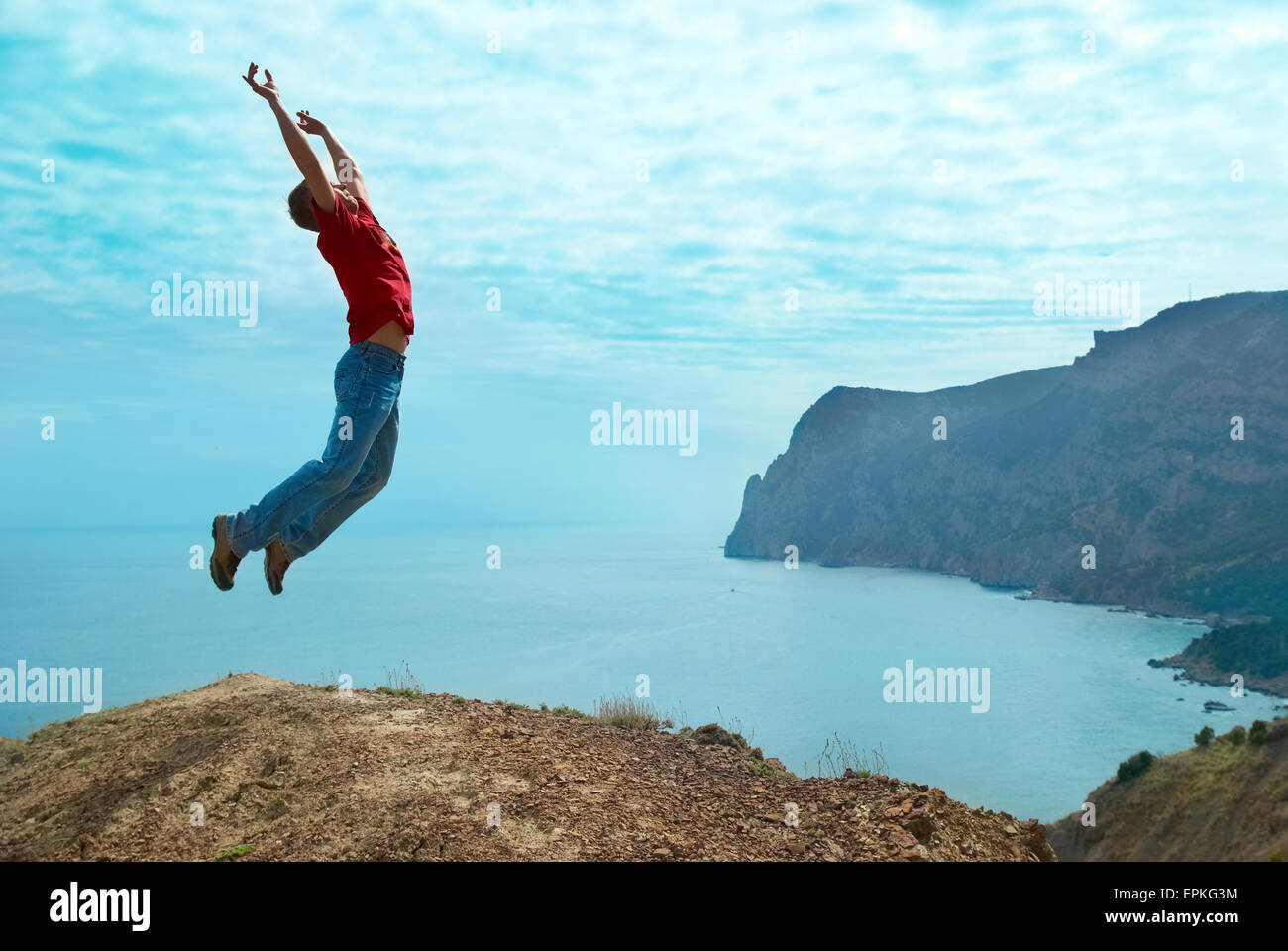 Man jumping cliff Stock Photo - Alamy