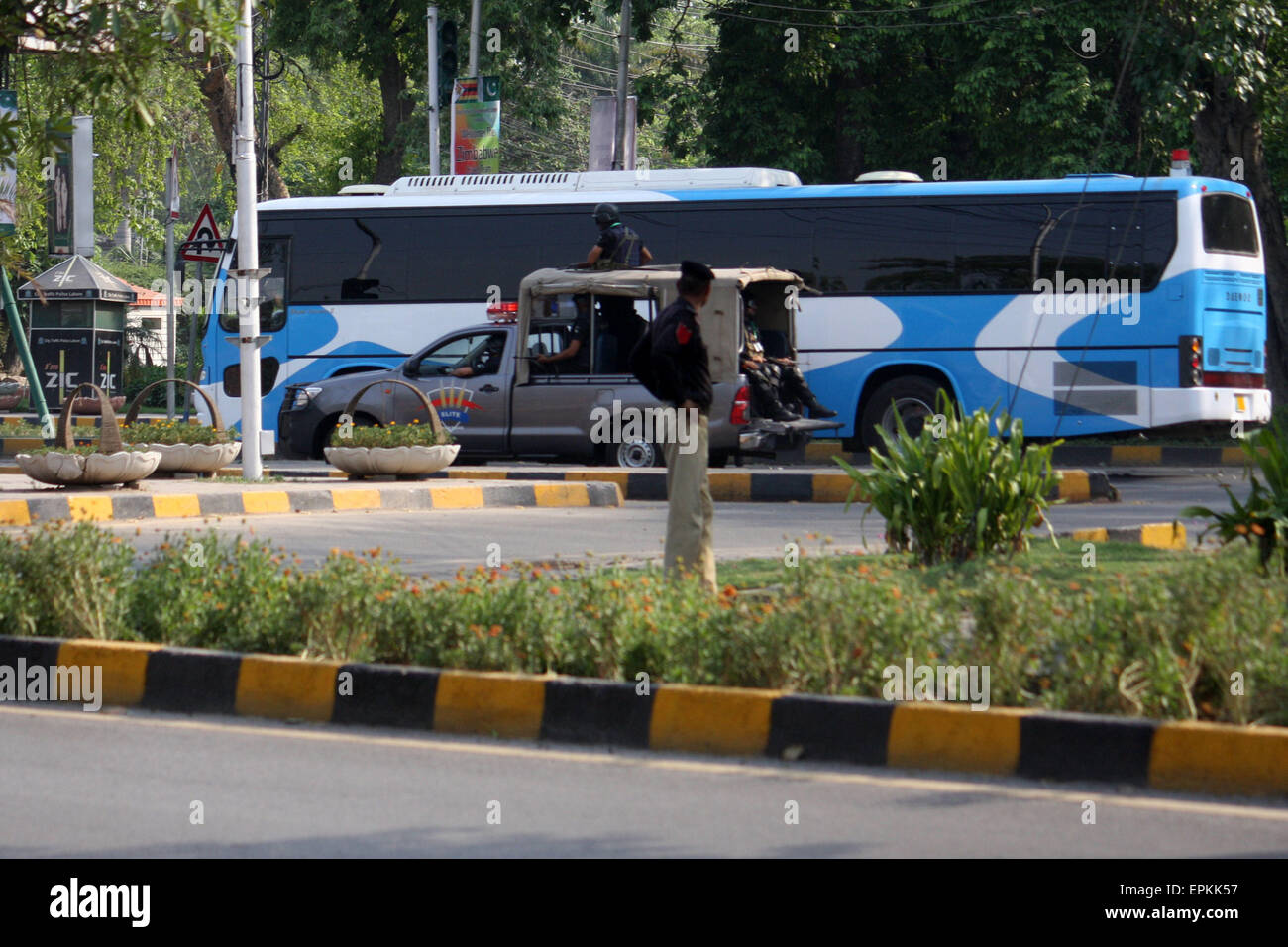 Lahore. 19th May, 2015. Pakistani policemen stand guard beside a bus ...