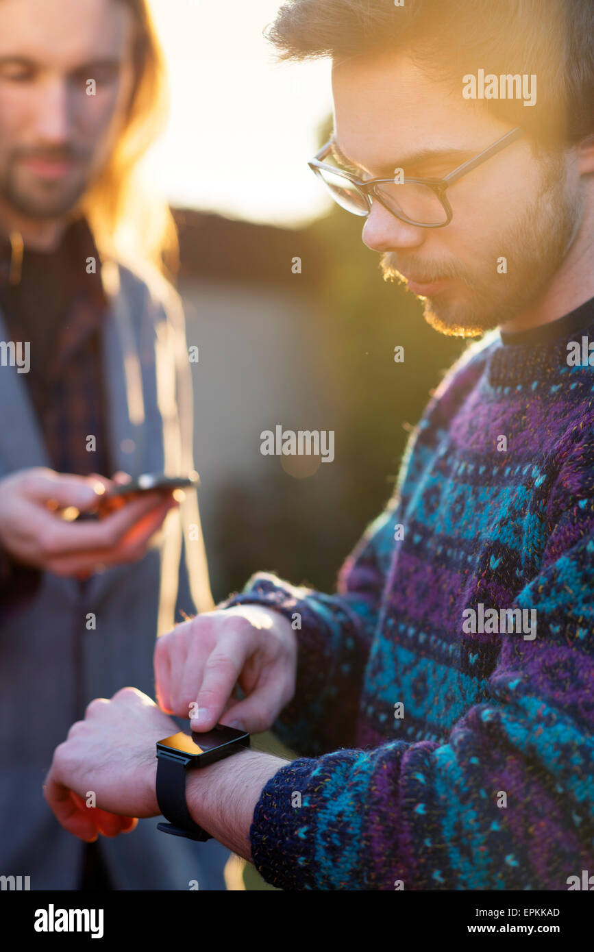Two hipsters with smartwatch and smartphone Stock Photo - Alamy