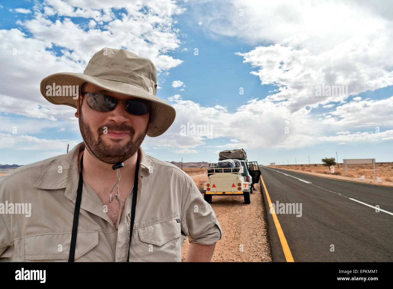 Namibia, Man with Safari hat and sunglasses with car at roadside in ...