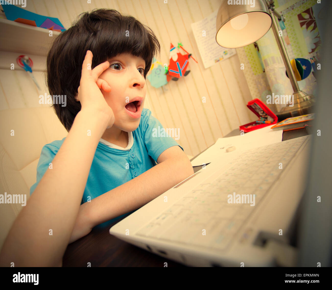 Surprised boy looking at a computer monitor Stock Photo - Alamy