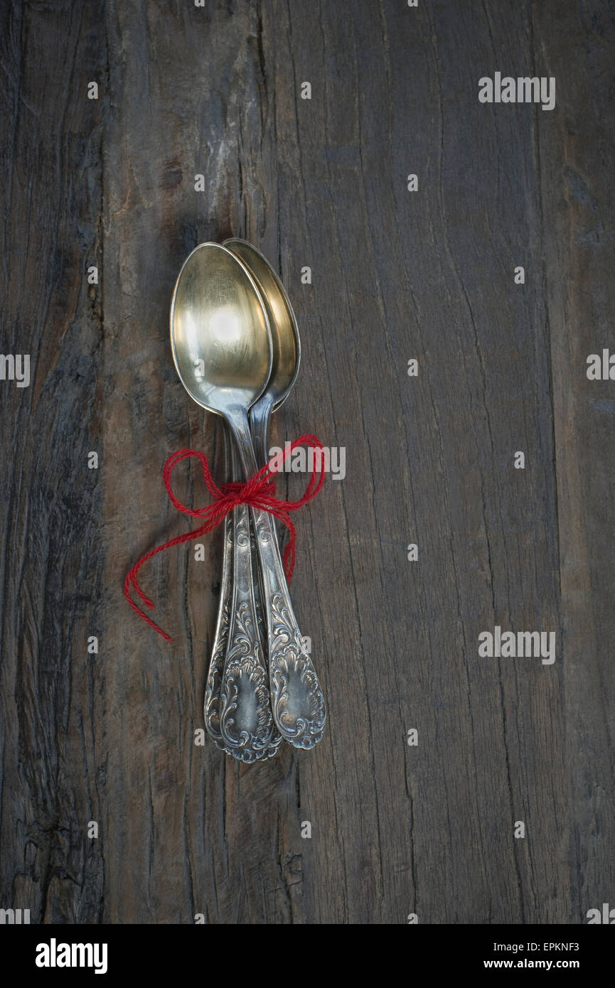 Old silver spoons tied together with red thread on dark wood Stock ...