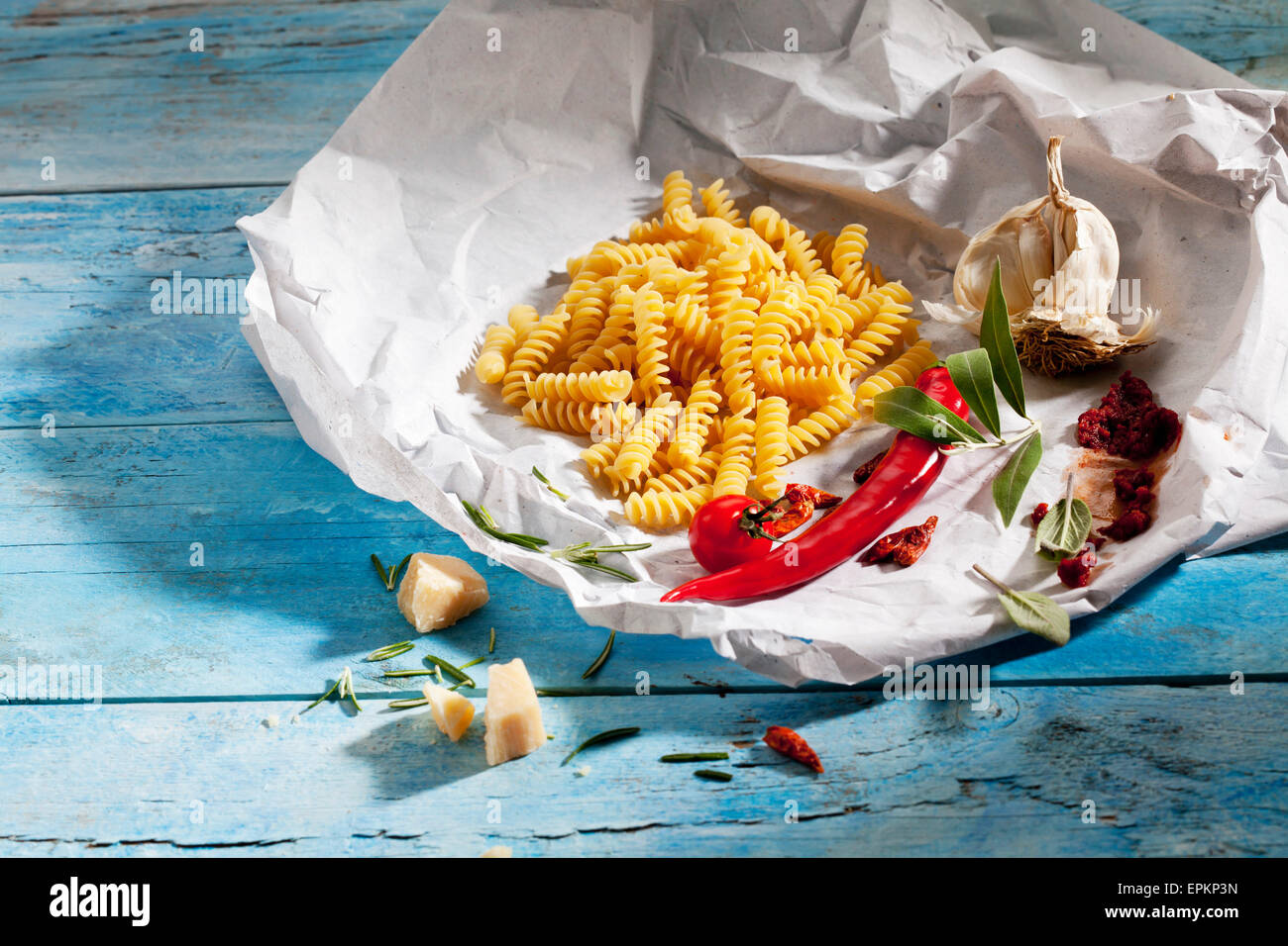 Uncooked Fusilli, chili pods, garlic, chili pepper, parmesan and tomato ...