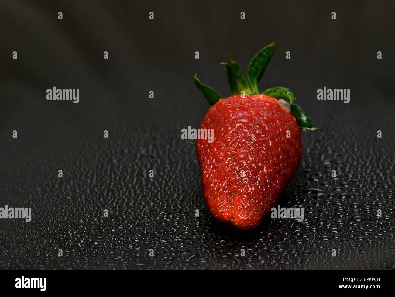 Fresh red single strawberry isolated on dark background, fresh fruits ...