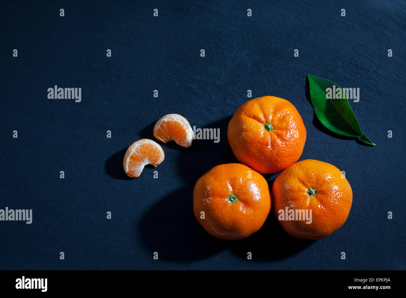 Three tangerines, leaf and pieces of tangerine Stock Photo - Alamy