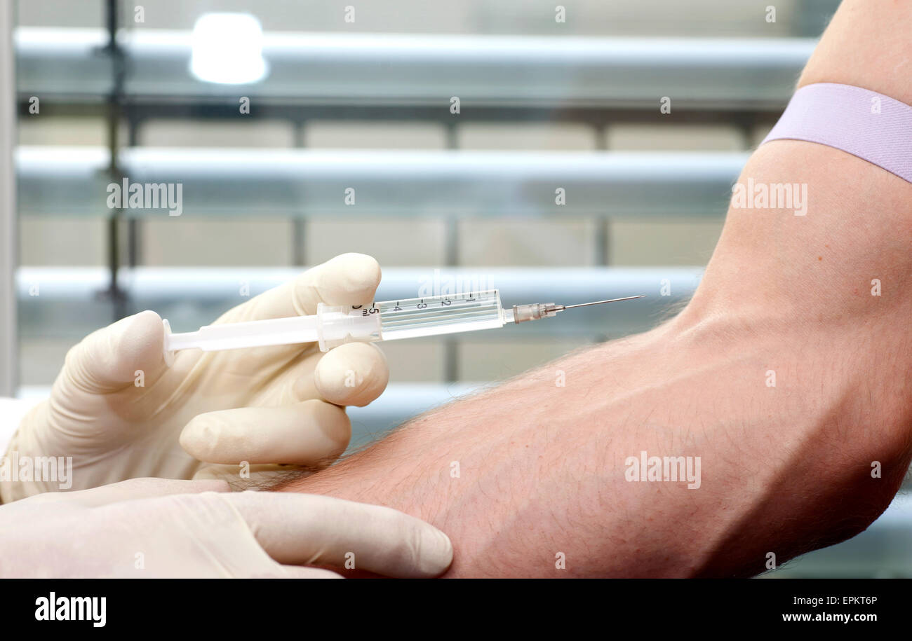 Man receiving injection in arm Stock Photo - Alamy