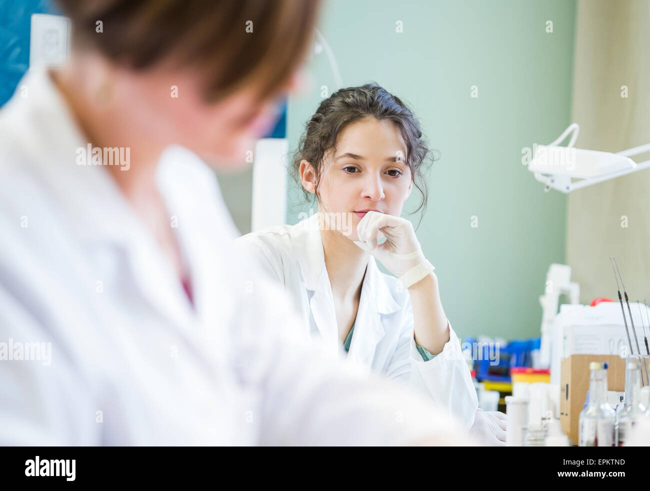 Young lab technician watching colleague at work Stock Photo - Alamy