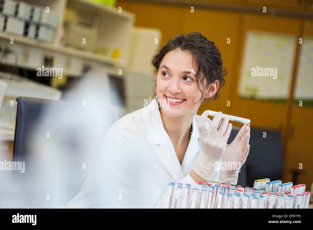 Smiling lab technician holding medical sample Stock Photo - Alamy