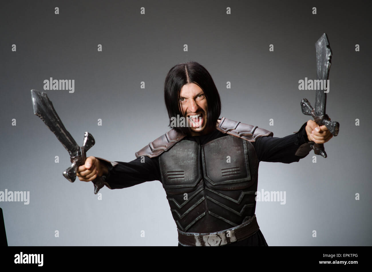 Angry knight with sword against dark background Stock Photo - Alamy