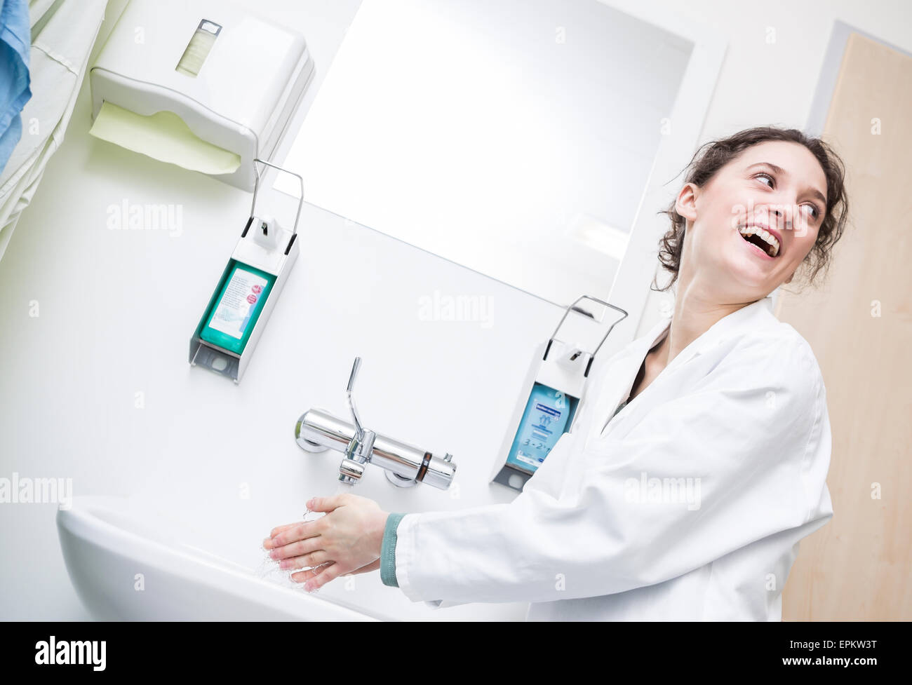 Smiling young lab technician washing hands Stock Photo - Alamy