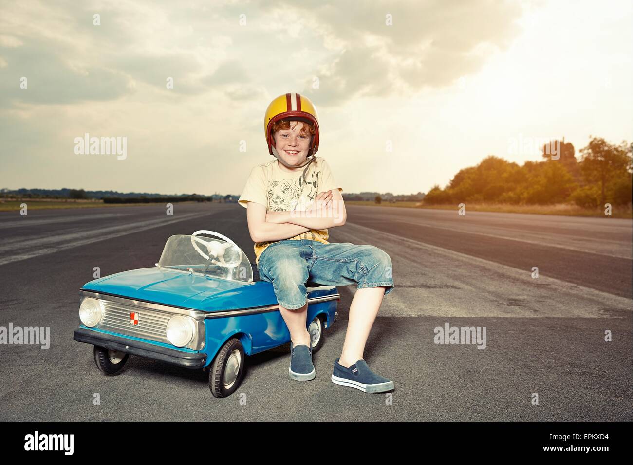 Smiling boy with pedal car on race track Stock Photo - Alamy