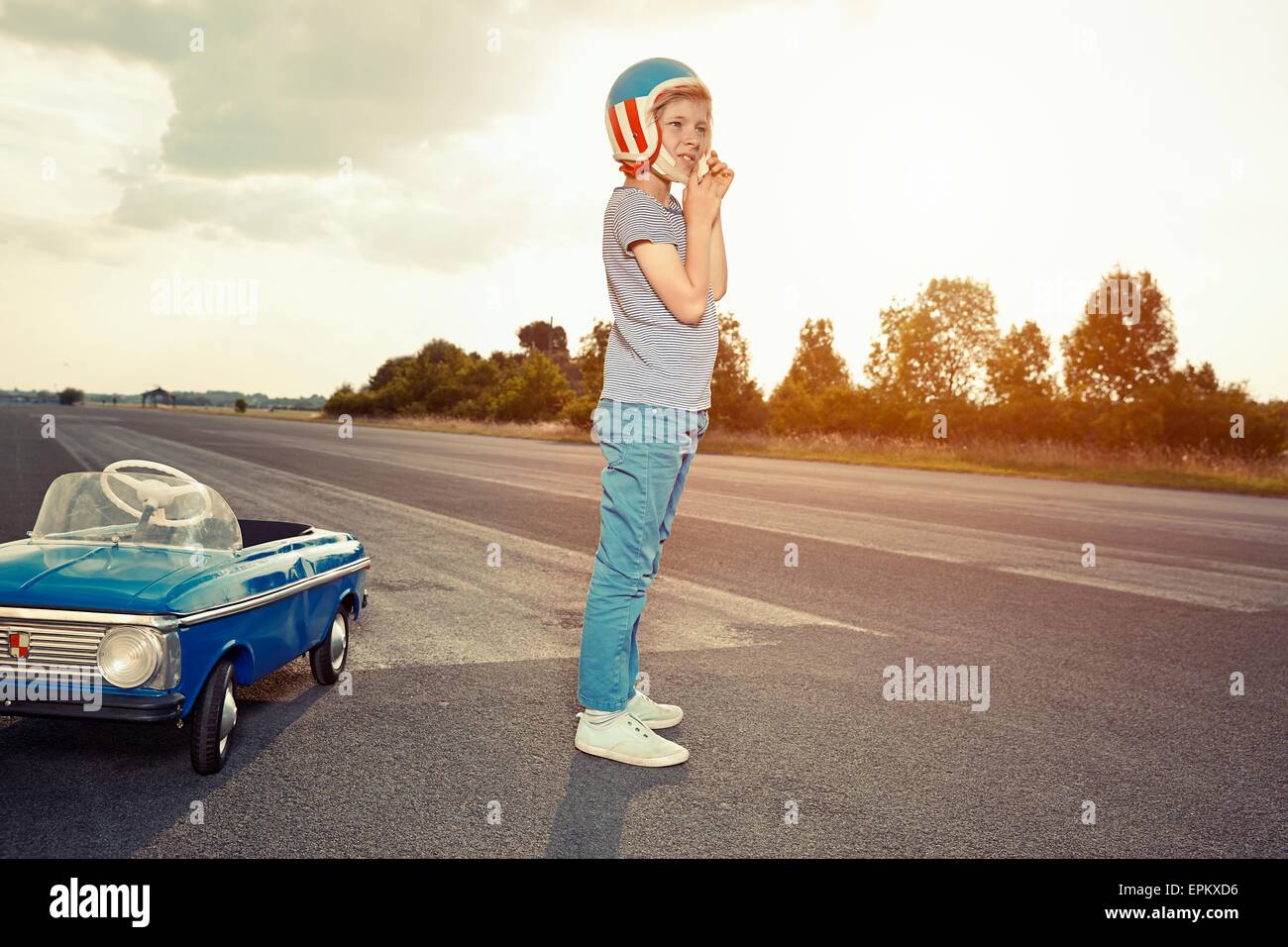 Boy standing next to pedal car on race track Stock Photo - Alamy