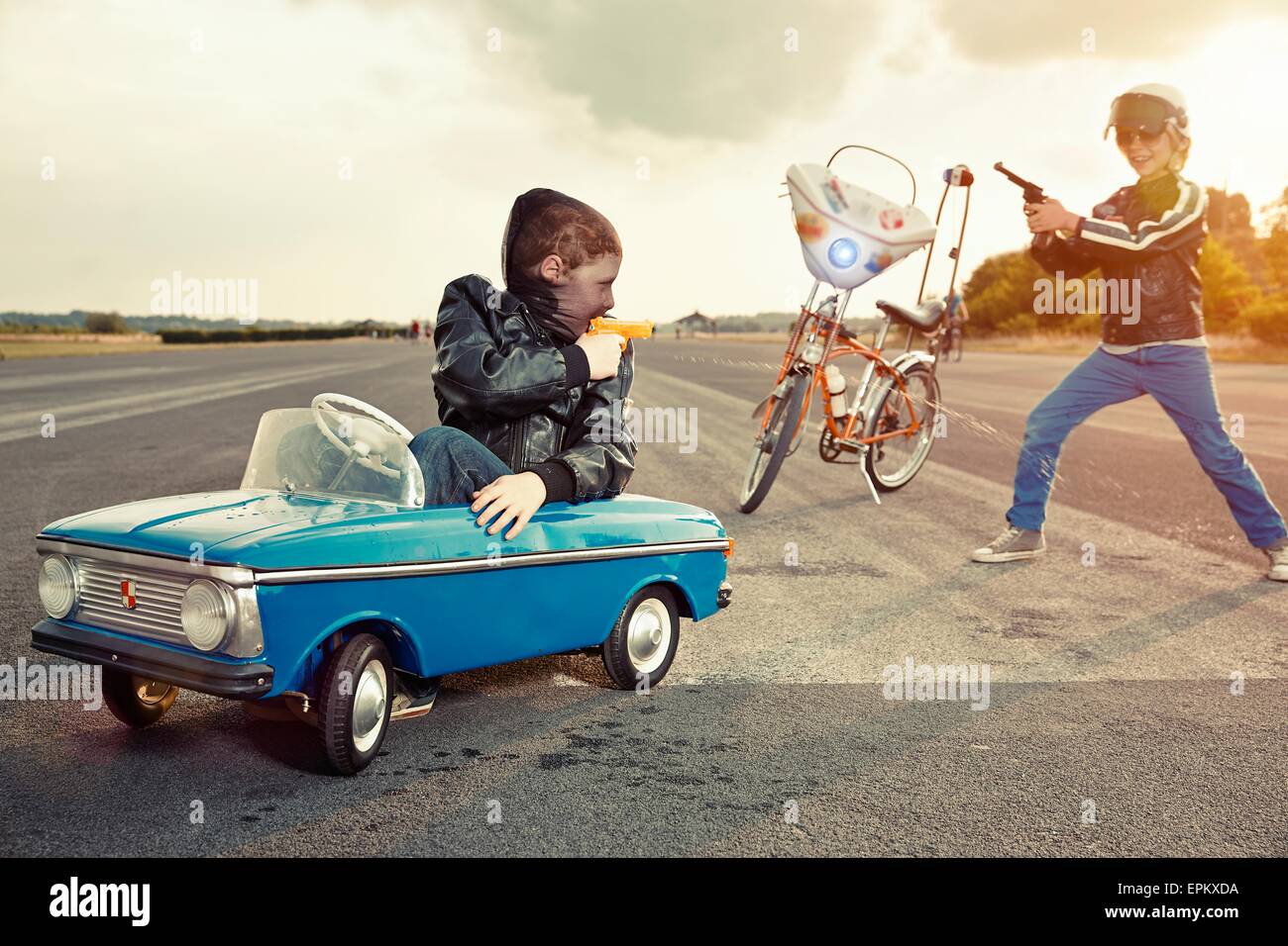 Two boys playing cops and robbers Stock Photo - Alamy