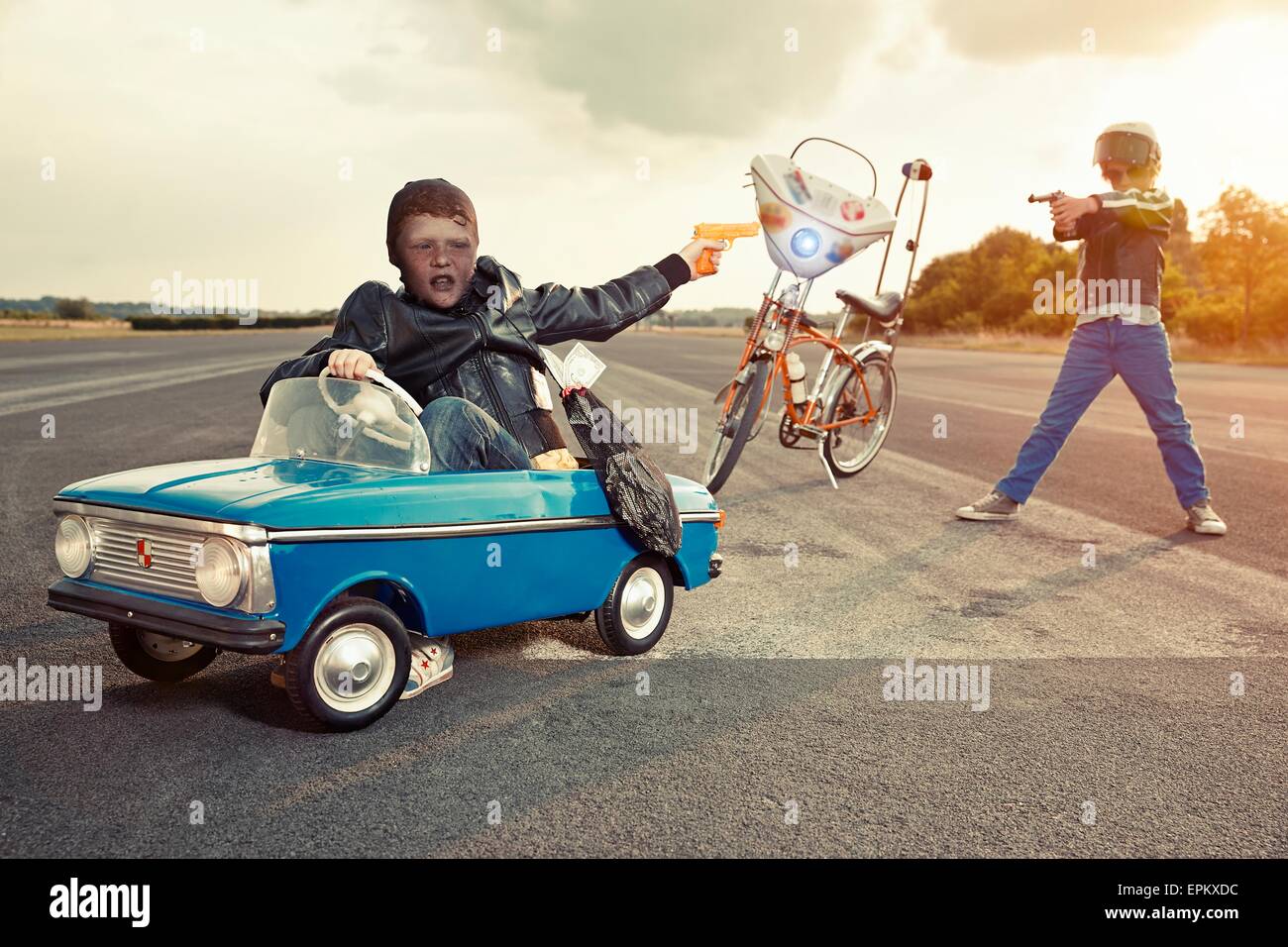 Two boys playing cops and robbers Stock Photo - Alamy