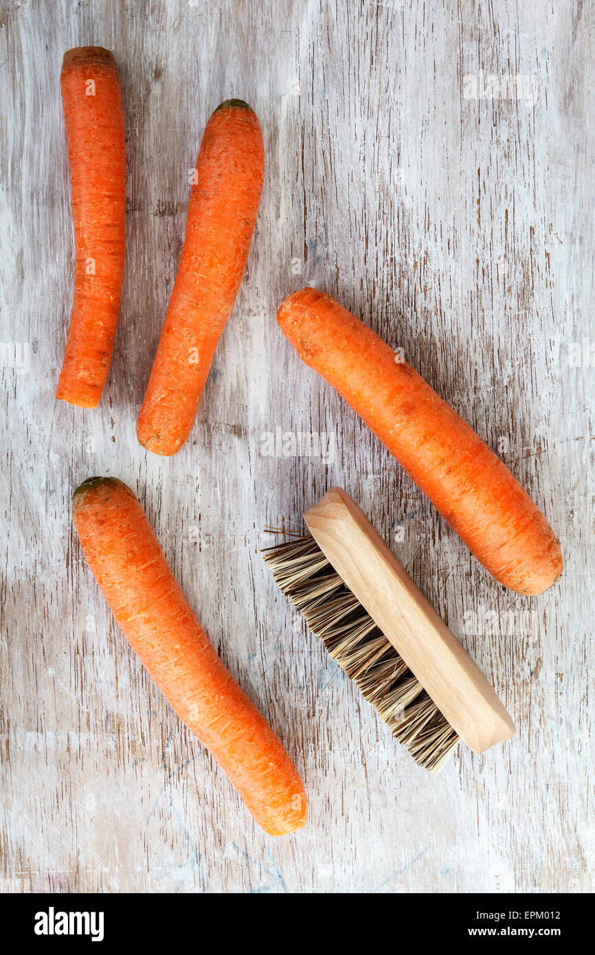 Four carrots and a vegetable brush Stock Photo - Alamy