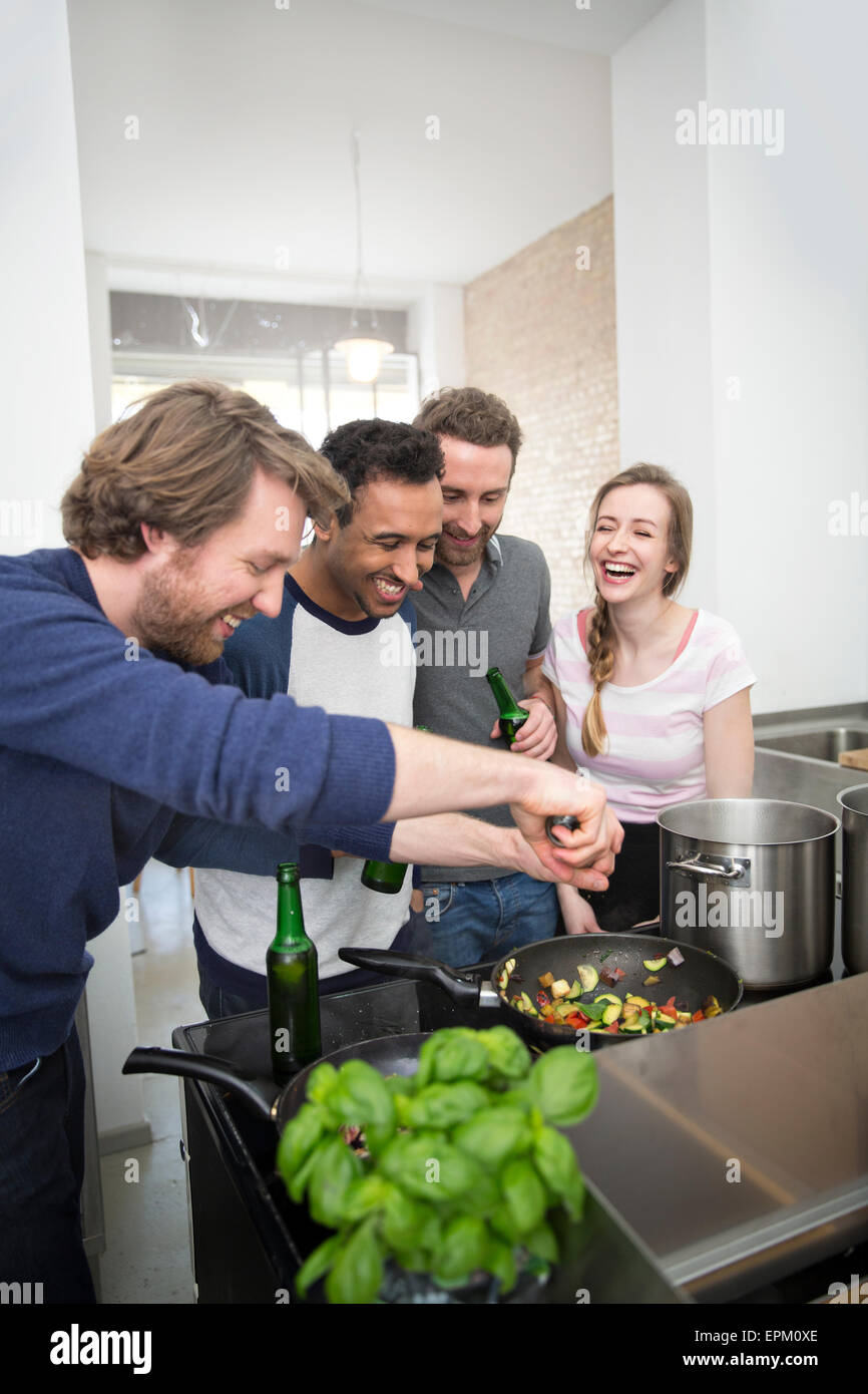 Happy friends cooking together Stock Photo - Alamy