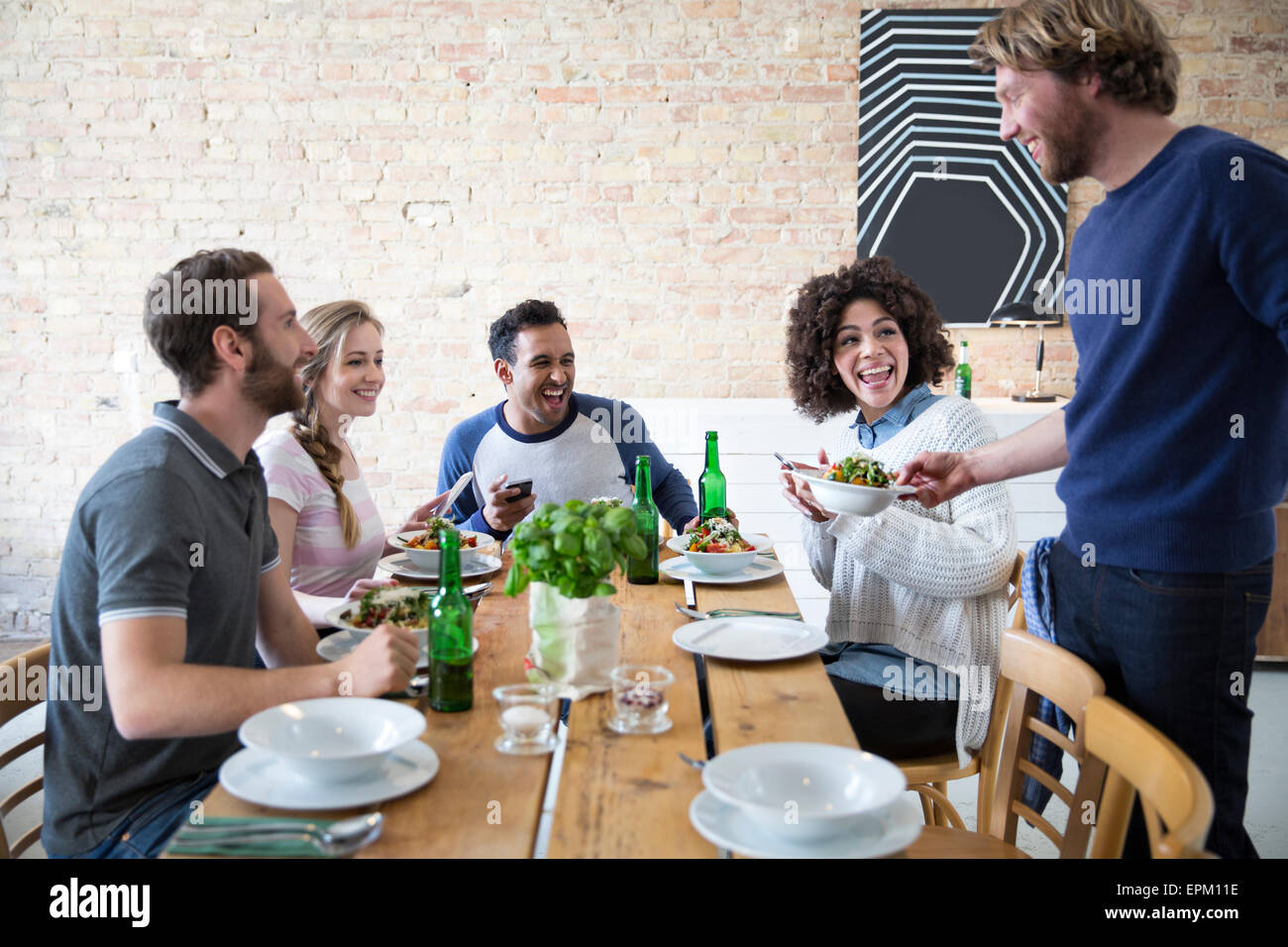 Happy friends eating together Stock Photo - Alamy