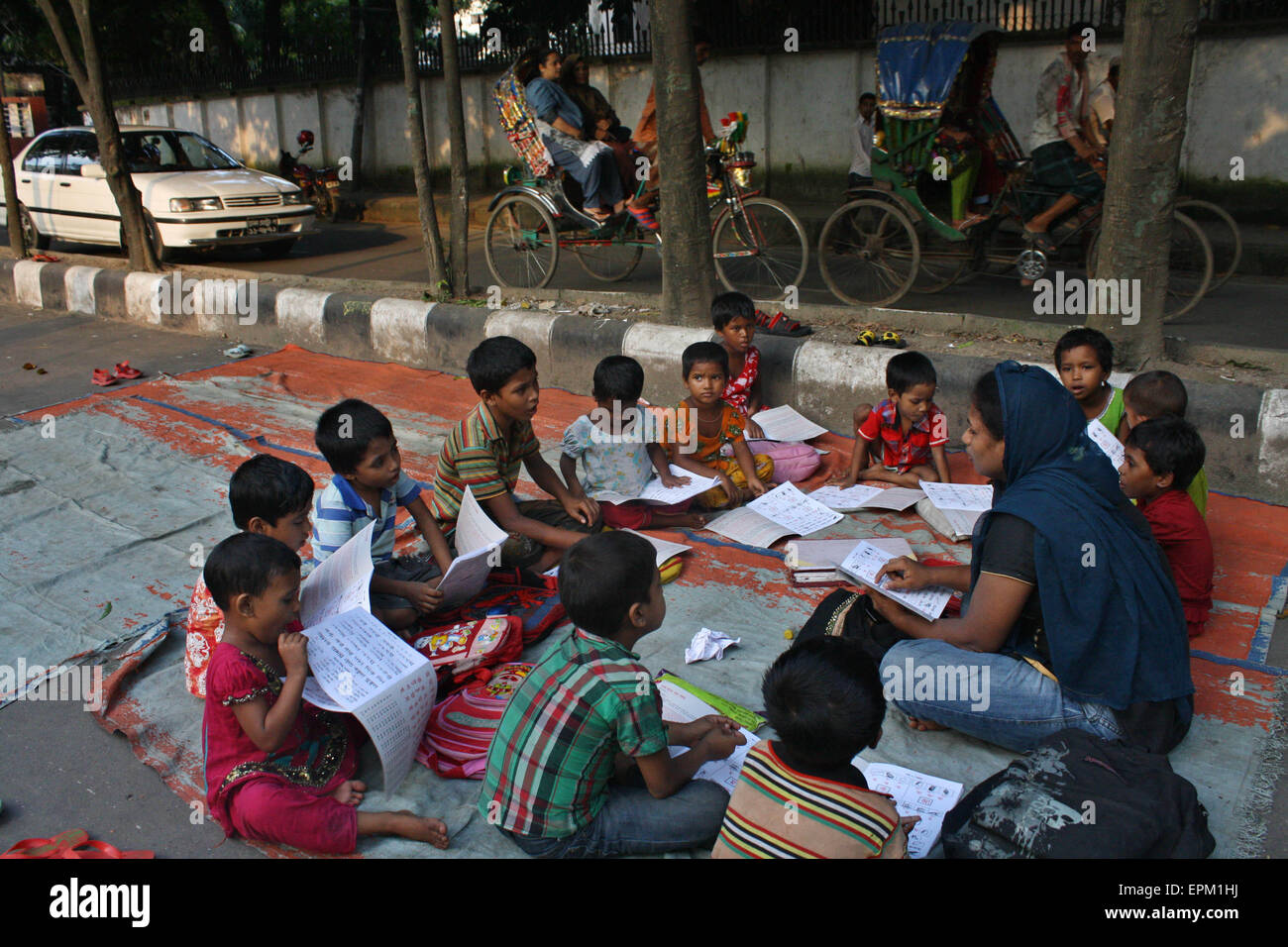 Bangladeshi street children study at the roadside at Poribug in Dhaka ...