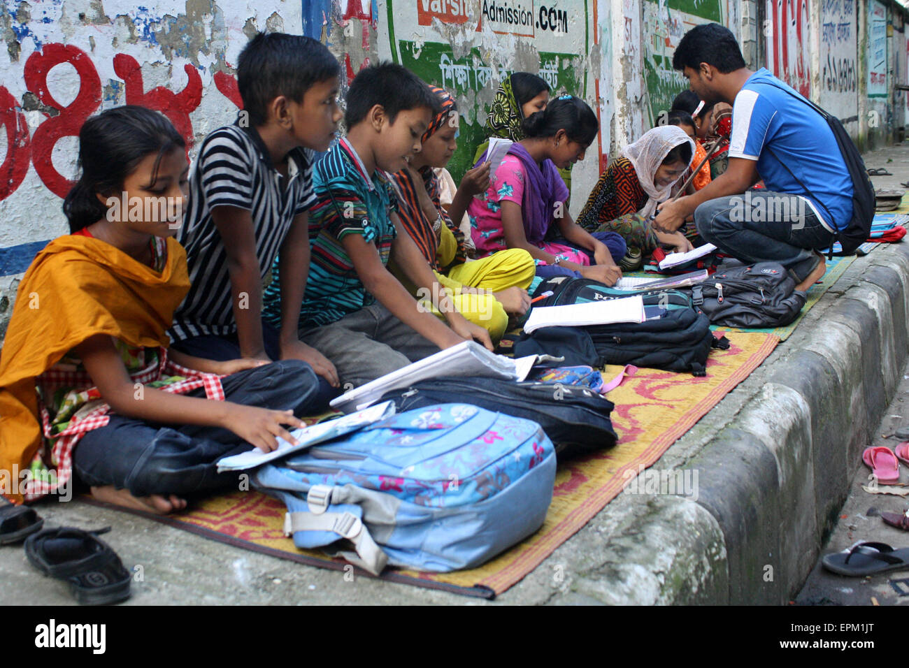 Bangladeshi street children study at the roadside at Poribug in Dhaka ...