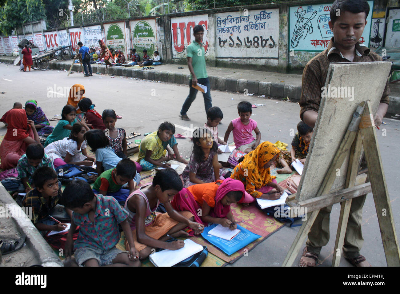 Bangladeshi street children study at the roadside at Poribug in Dhaka ...
