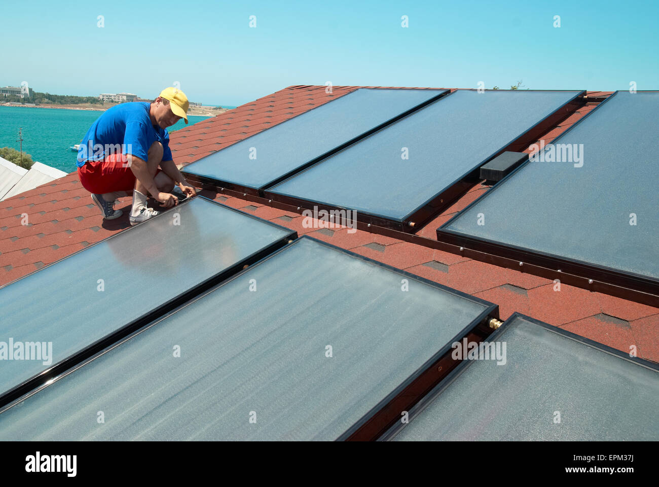 Worker installs solar panels Stock Photo - Alamy