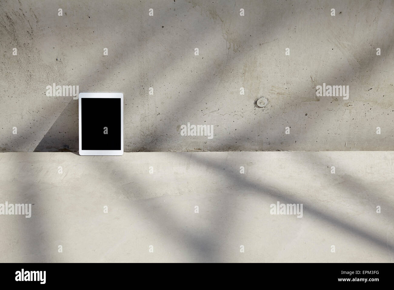 Digital tablet on concrete floor Stock Photo - Alamy