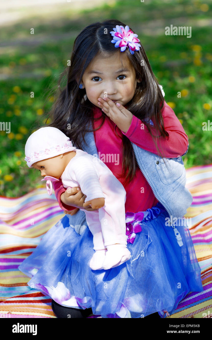 Little girl outdoors playing with a doll Stock Photo - Alamy