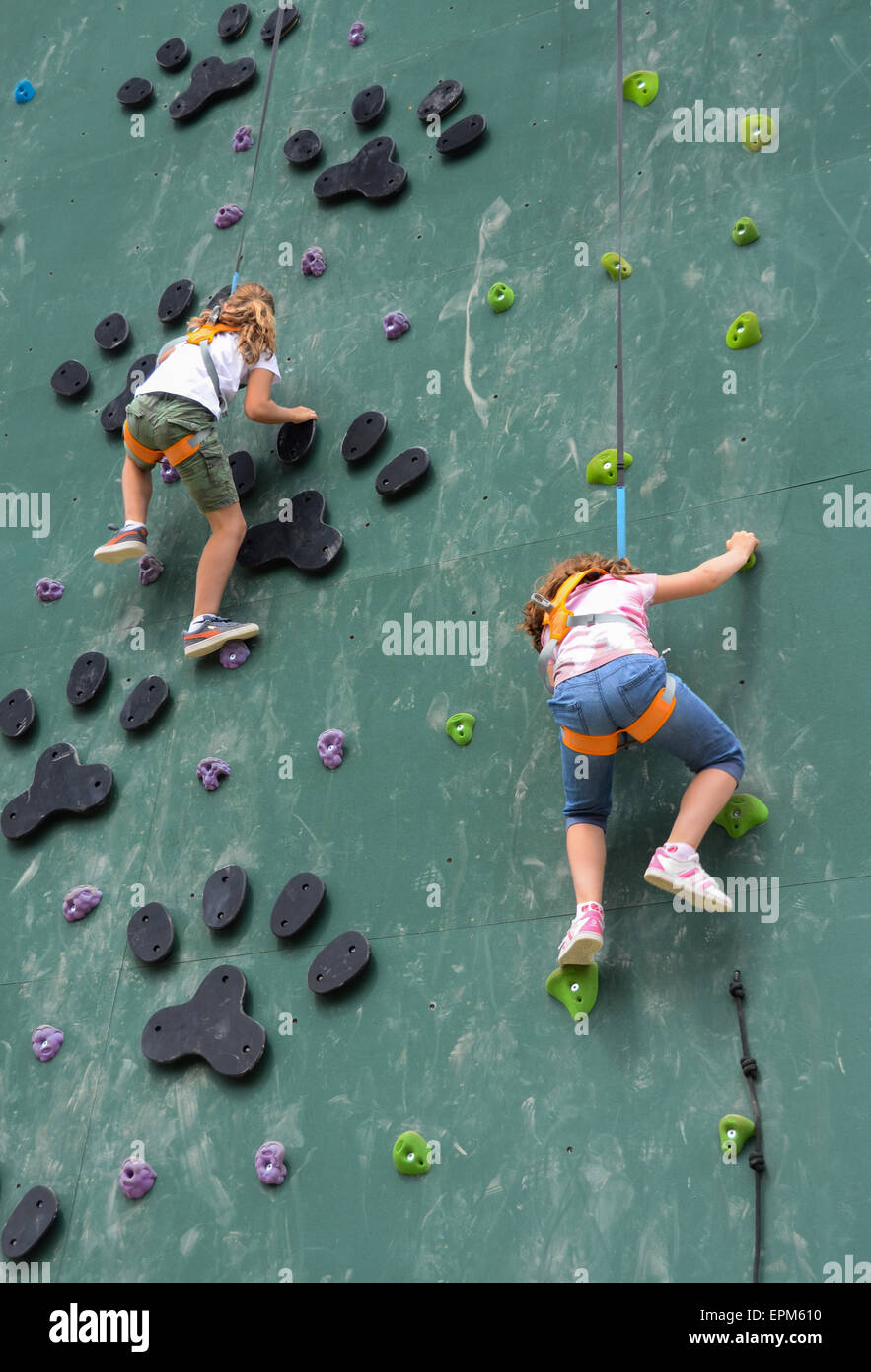 Young girls having an adventure climbing and jumping at a fun park ...