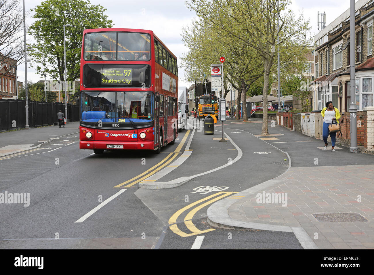 London cycle path. A bus pulls away from a new 'floating' bus stop ...