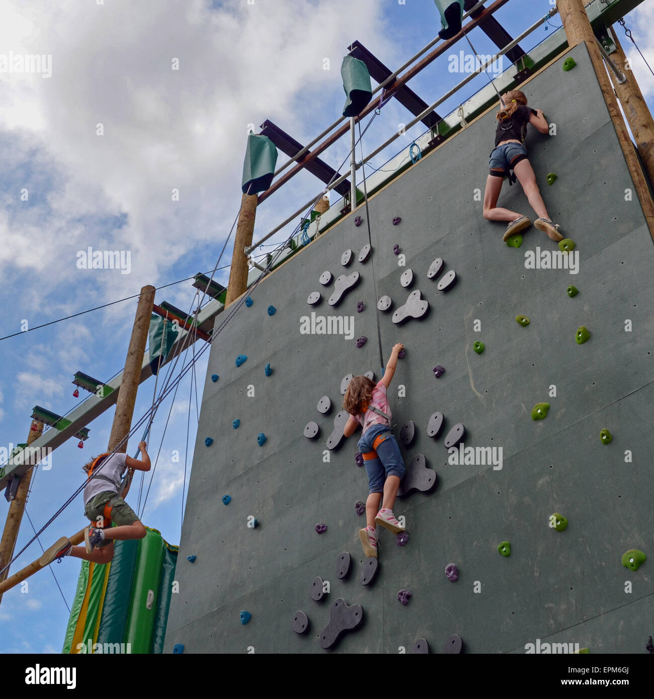 Young girls having an adventure climbing and jumping at a fun park ...