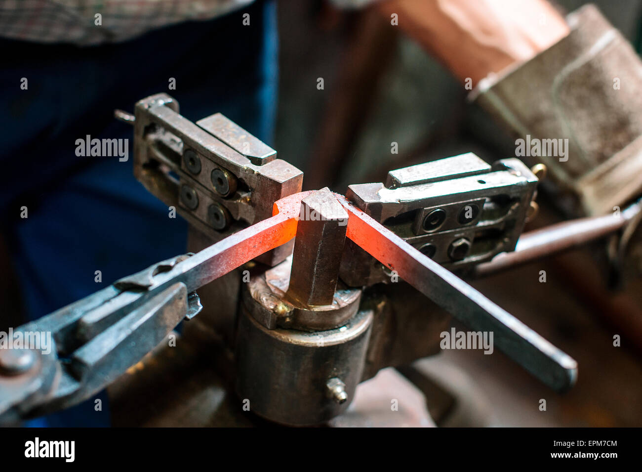 Blacksmith bending hot iron Stock Photo - Alamy