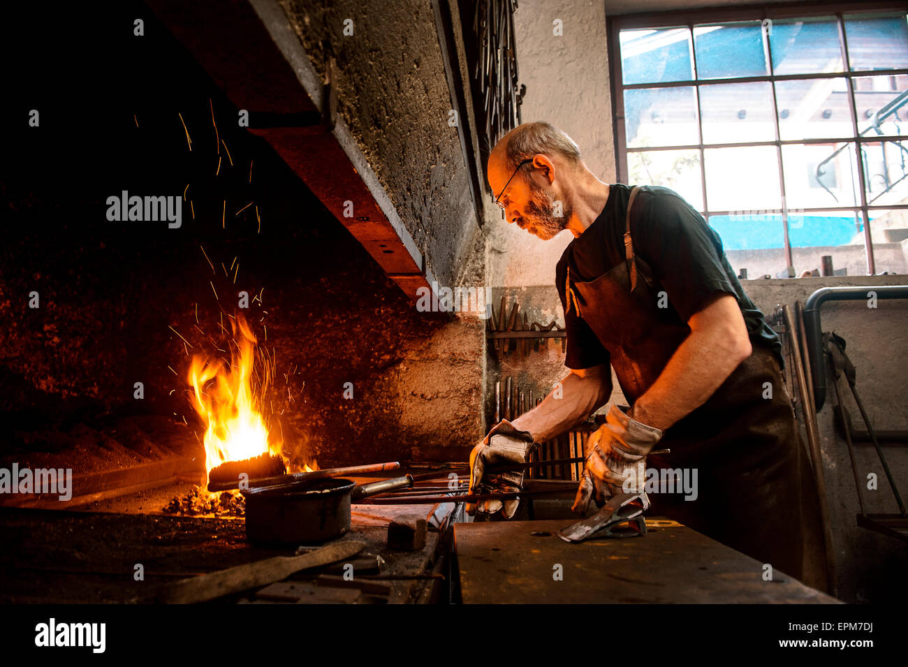 Senior blacksmith working in hammer mill Stock Photo - Alamy