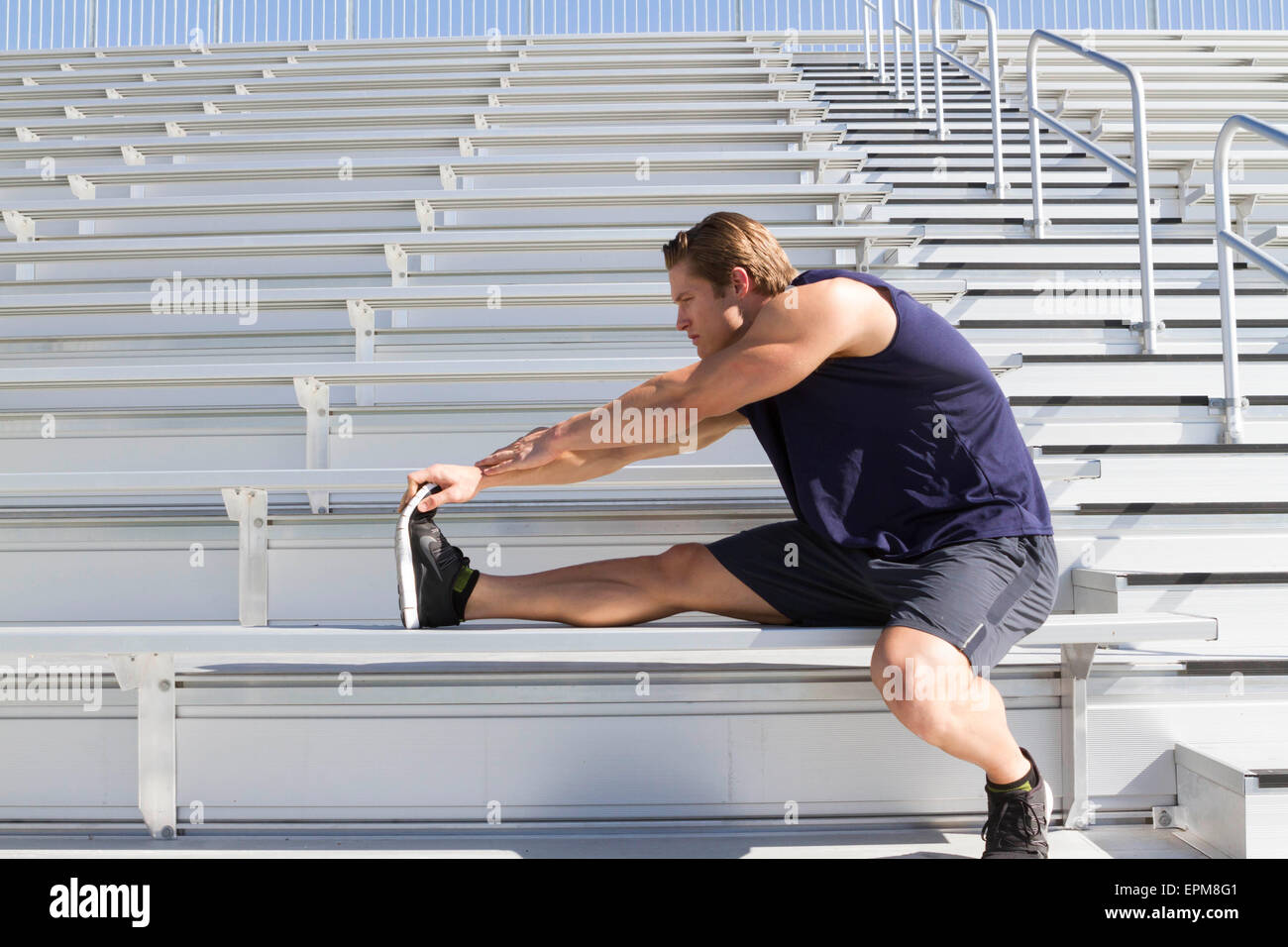 USA, California, San Luis Obispo, young man doing stretching exercises ...