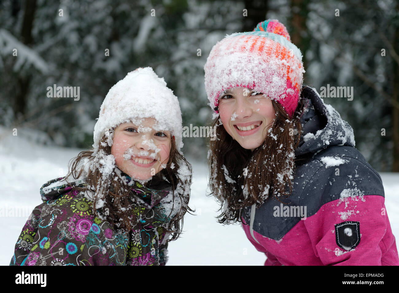 Two girls having fun in the snow Stock Photo - Alamy
