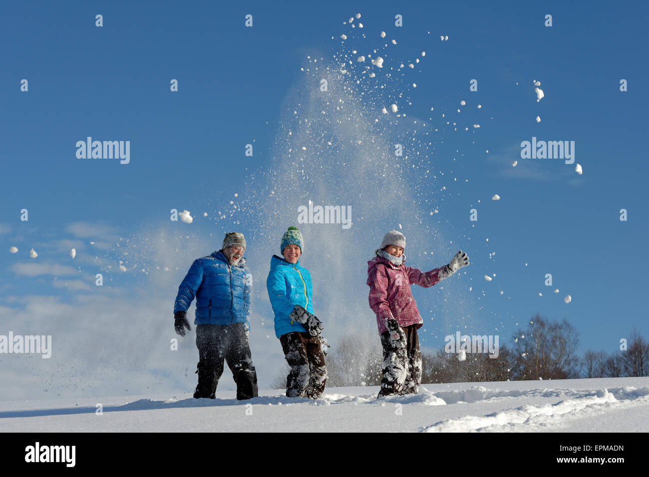 Father and two children having fun in the snow Stock Photo - Alamy