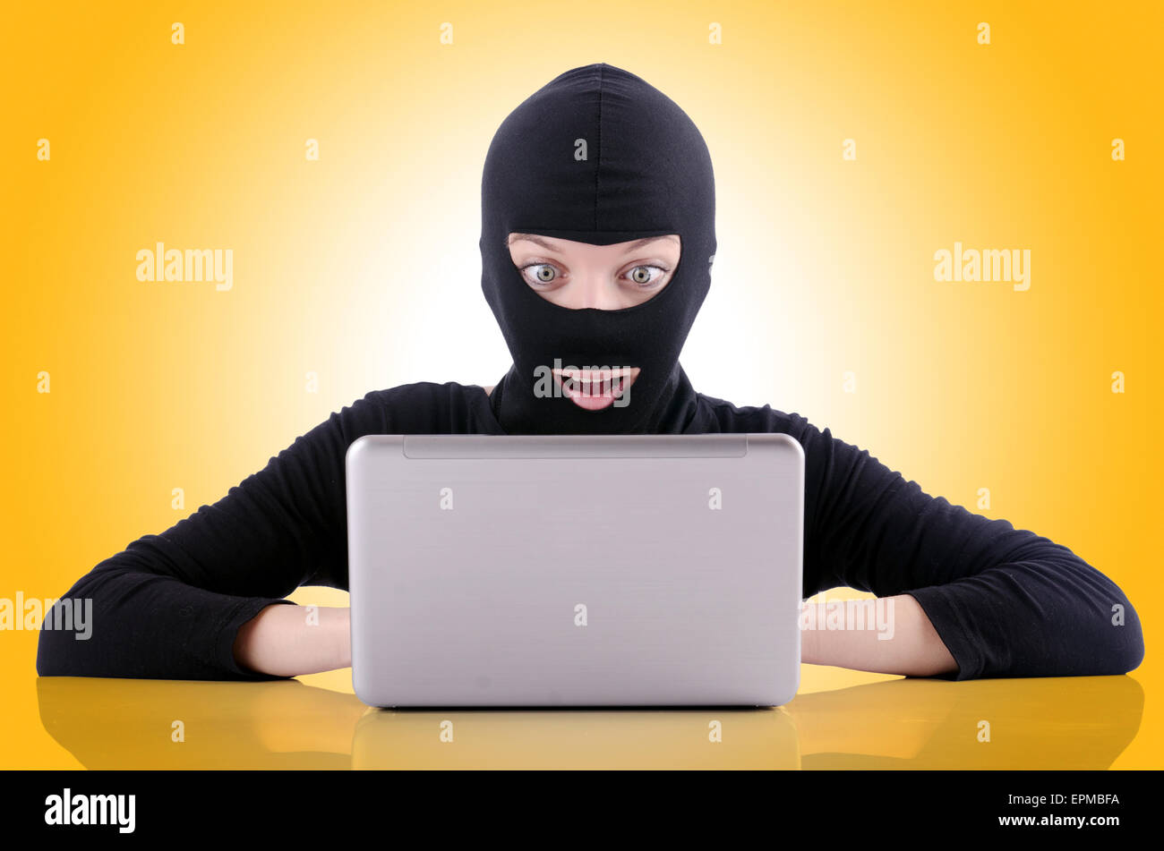 Hacker with computer wearing balaclava Stock Photo - Alamy
