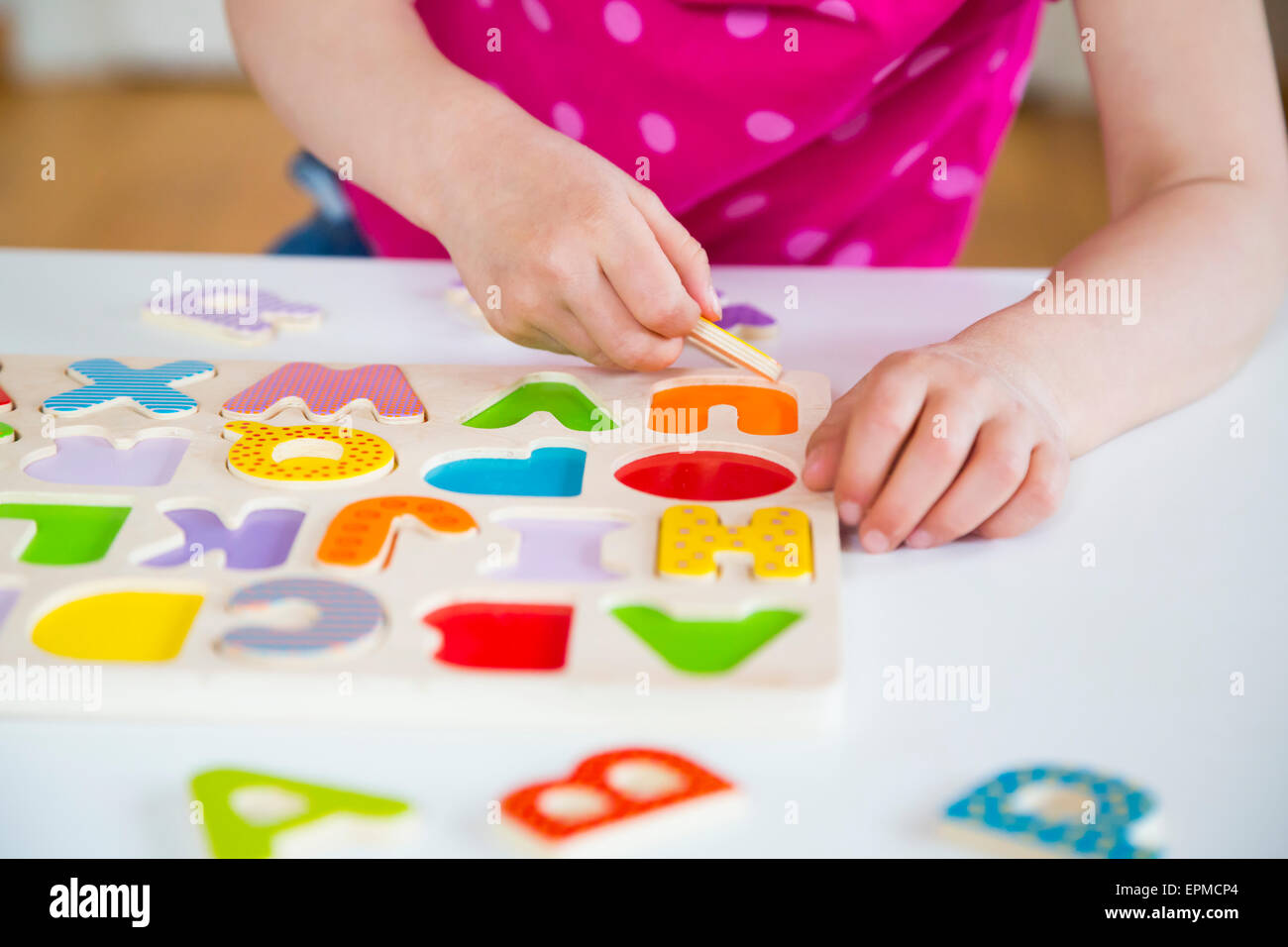 Little girl learning alphabet with wooden letters Stock Photo - Alamy