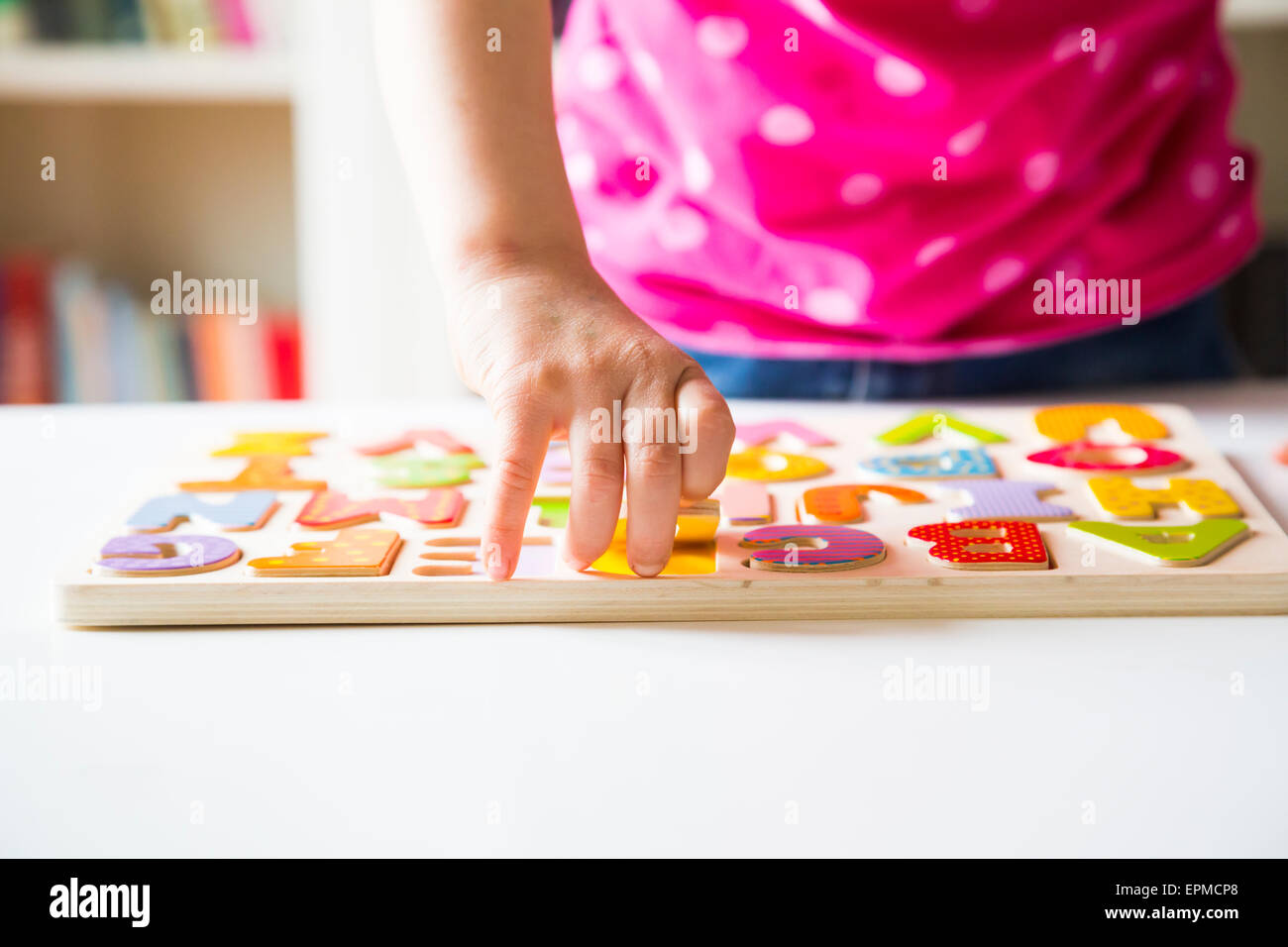 Little girl learning alphabet with wooden letters Stock Photo - Alamy