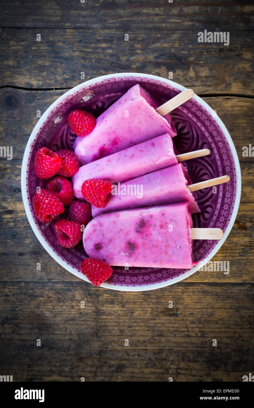 Bowl with raspberry chia ice lollies and raspberries Stock Photo - Alamy