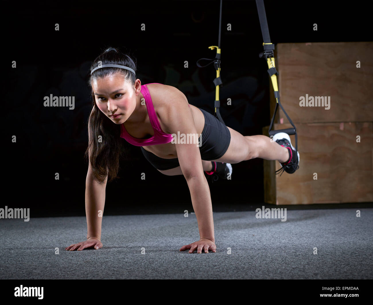 Young woman doing suspension training Stock Photo - Alamy