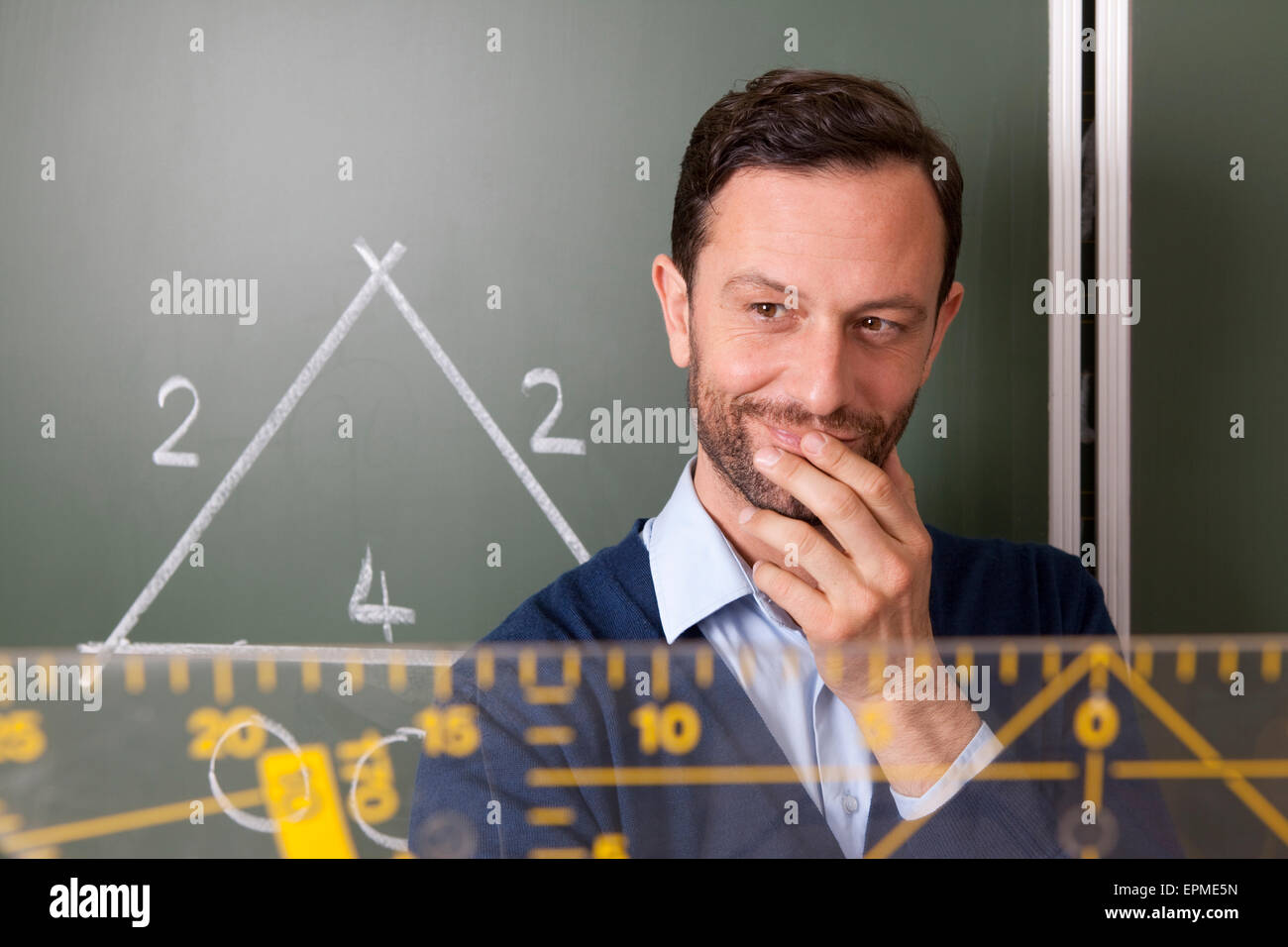 Smiling teacher in classroom teaching geometry Stock Photo - Alamy