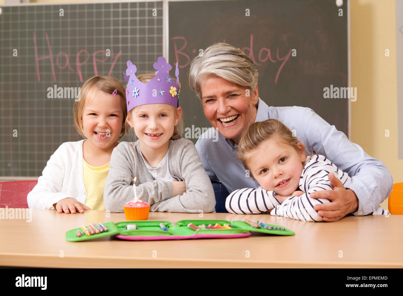 Portrait of happy teacher and schoolgirls celebrating birthday in ...