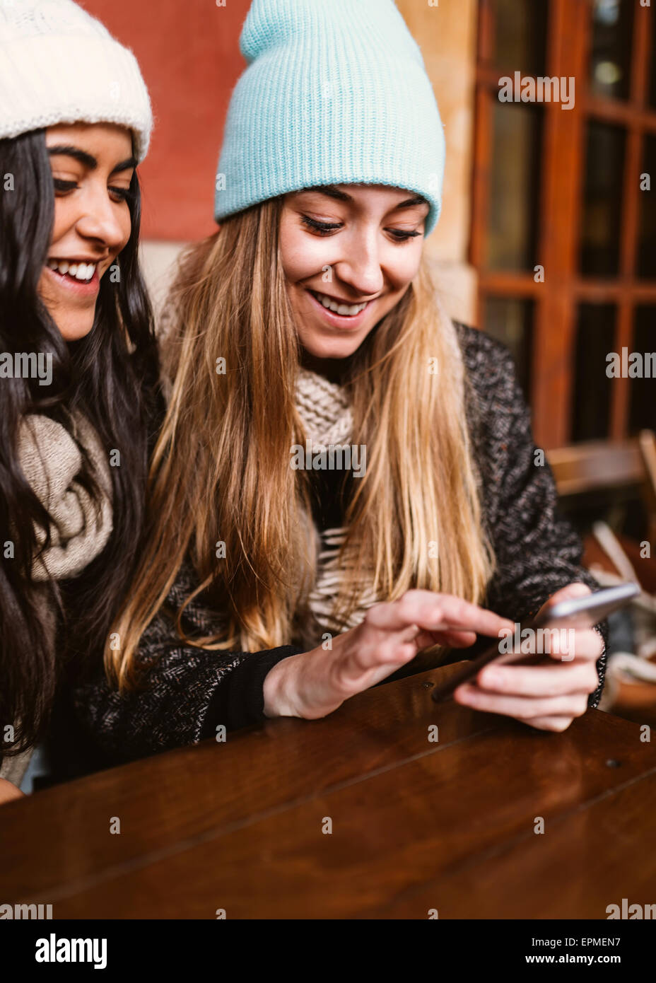 Two young women sending message with smartphone Stock Photo - Alamy