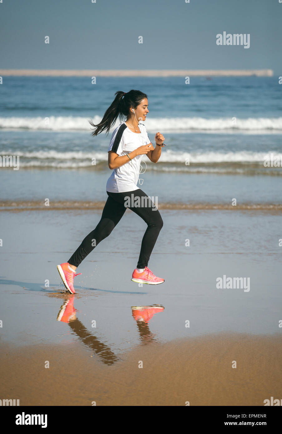 Spain, Gijon, young woman running on the beach Stock Photo - Alamy