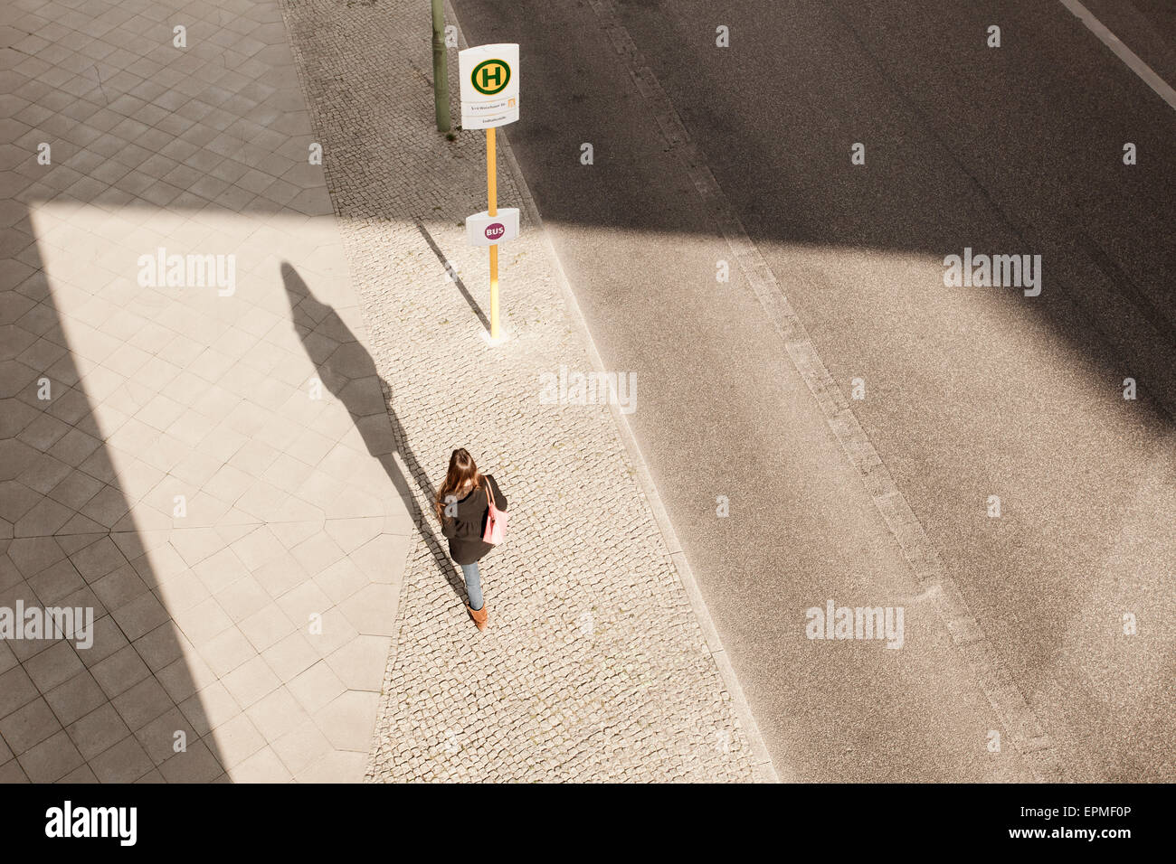 Young woman walking to bus stop Stock Photo - Alamy