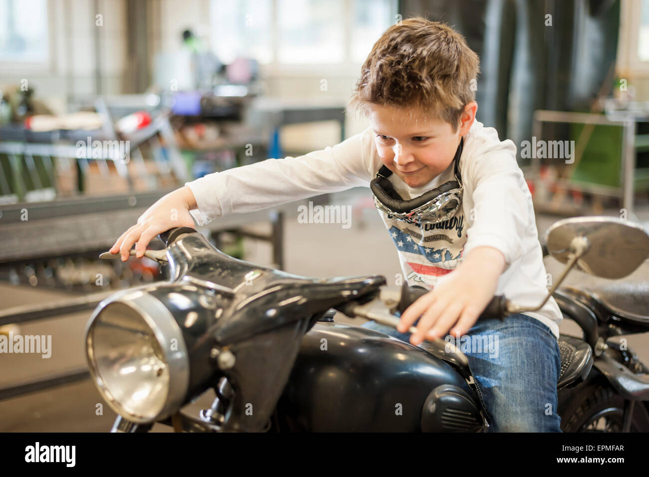 Boy pretending to drive vintage moped Stock Photo - Alamy