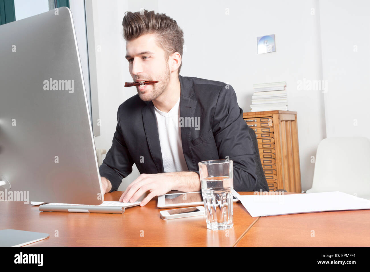 Young man working at desk in an office Stock Photo - Alamy