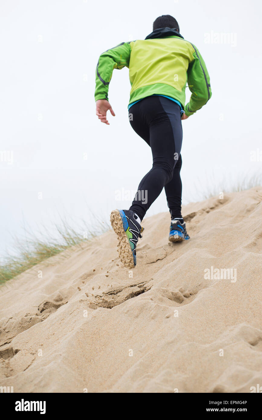 Spain, Galicia, Valdovino, man running up a dune on the beach Stock ...