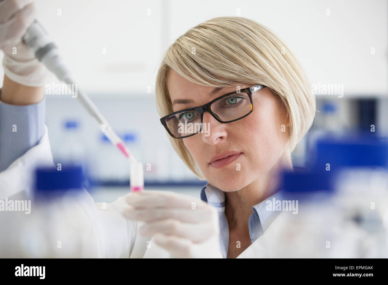 Scientist pouring liquid in test tube Stock Photo - Alamy